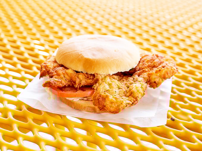 The legendary sandwich that laughs at bun proportions. Three inches of crispy-fried beef overhang that makes first-timers ask, "Do I need a permit for this?"