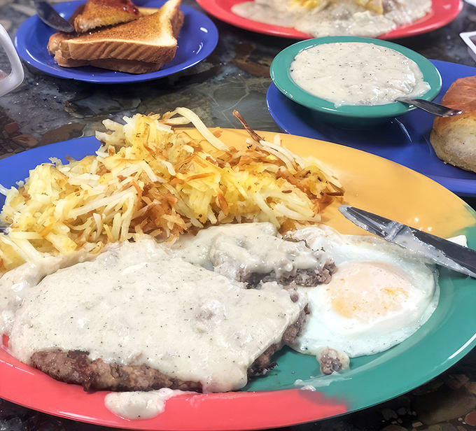 
Behold the star attraction: chicken fried steak swimming in pepper-flecked gravy alongside eggs and hashbrowns that would make your grandmother weep with joy.
