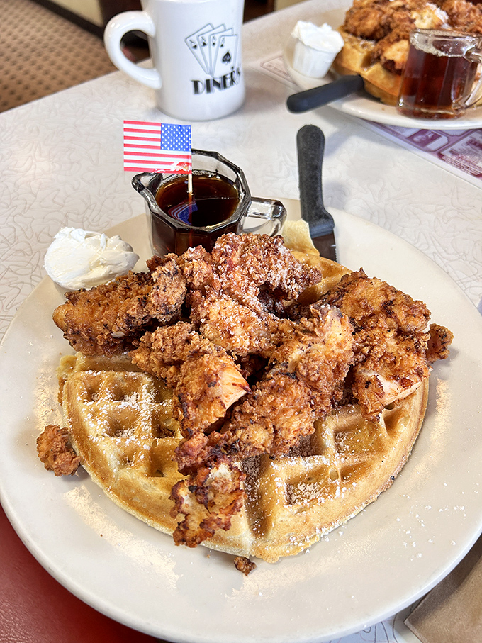 Chicken and waffles: where breakfast and dinner have a delicious identity crisis. That tiny American flag isn't just patriotic—it's claiming territory in comfort food heaven.