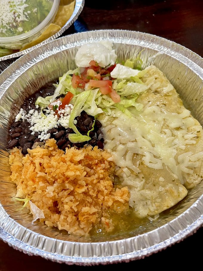 Behold the enchilada plate in all its glory—where cheese, sauce, rice, and beans perform a harmonious quartet that would make Mozart jealous.