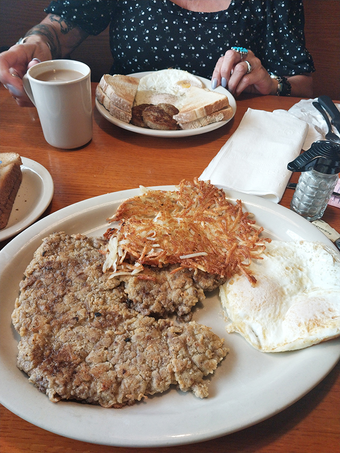 The holy trinity of breakfast perfection: chicken fried steak with a golden crust, crispy hash browns, and eggs that didn't come from a carton.