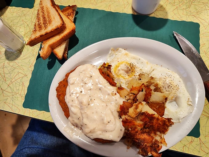 The holy trinity of comfort food: golden-brown chicken fried steak, creamy gravy, and home fries that make you question why you ever ate kale.