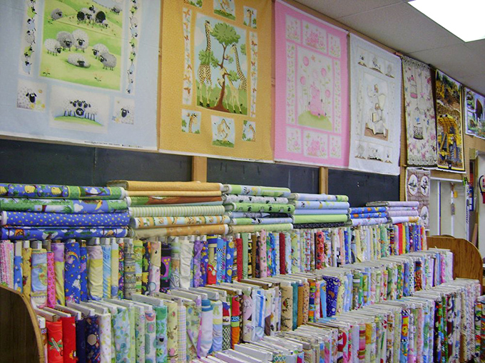 Whimsical panels featuring sheep, giraffes, and bunnies line the walls above bolts of children's fabrics&mdash;future blankets and stuffed animals in waiting.