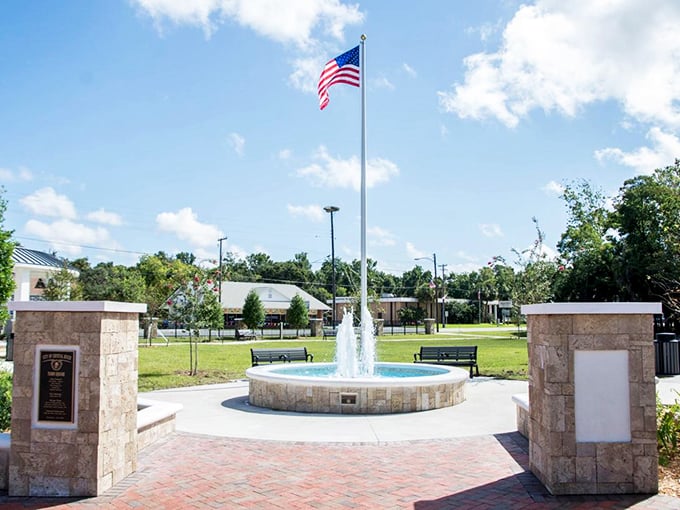 A pristine fountain plaza with the American flag standing tall. This peaceful corner of Crystal River offers a moment of reflection between manatee adventures.