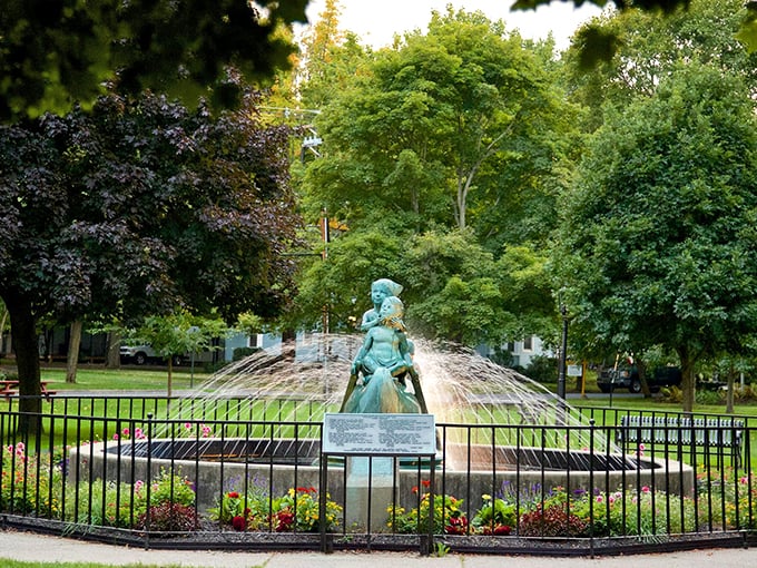Colorful flower beds surround the historic fountain in Wellsboro's central park, creating a peaceful oasis where locals and visitors gather.