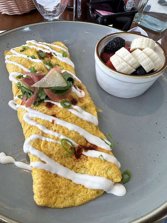 Sunshine on a plate! This golden omelet drizzled with crema and paired with fresh fruit is breakfast's answer to having your cake and eating it too.