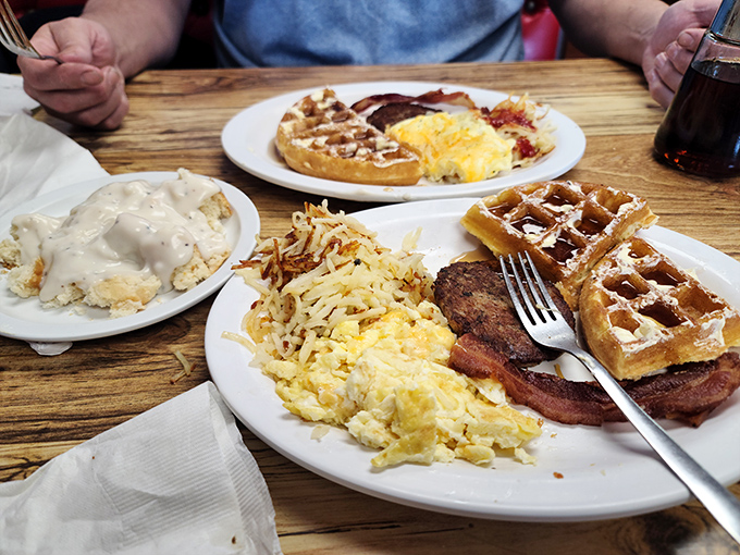 Waffles, eggs, and hash browns sharing a plate like old friends at a reunion. This isn't just breakfast; it's morning bliss on porcelain.