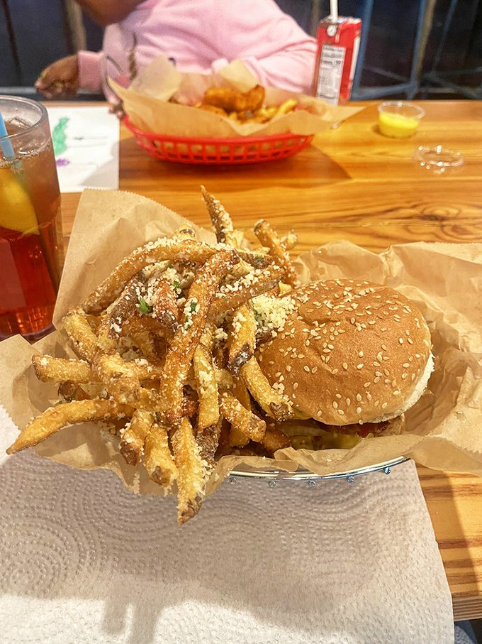 Parmesan-dusted fries that could make an Italian grandmother weep with joy, paired with a burger that demands a moment of reverential silence.