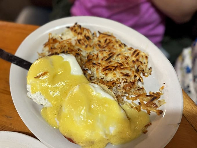Eggs Benedict with a golden hollandaise cascade that would make Niagara Falls jealous. Those hash browns deserve their own fan club.
