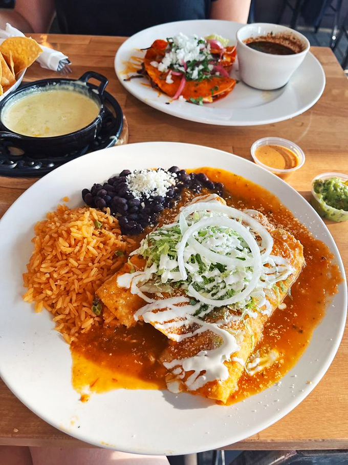 These enchiladas are dressed to impress—wearing their red sauce like a designer outfit, with rice and beans as perfectly matched accessories.