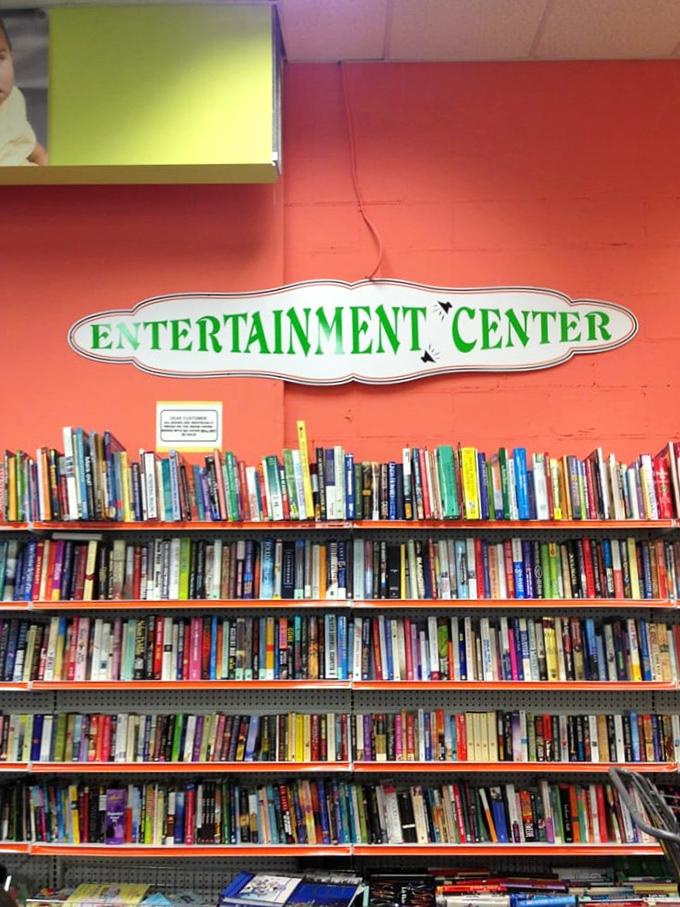 The "Entertainment Center" sign promises literary adventures for every taste. From bestsellers to obscure gems, your next favorite book is hiding somewhere on these shelves.