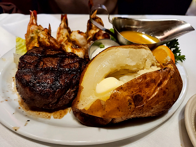 A perfectly seared filet mignon shares the plate with jumbo prawns and a loaded baked potato. This isn't a meal; it's a celebration on china.