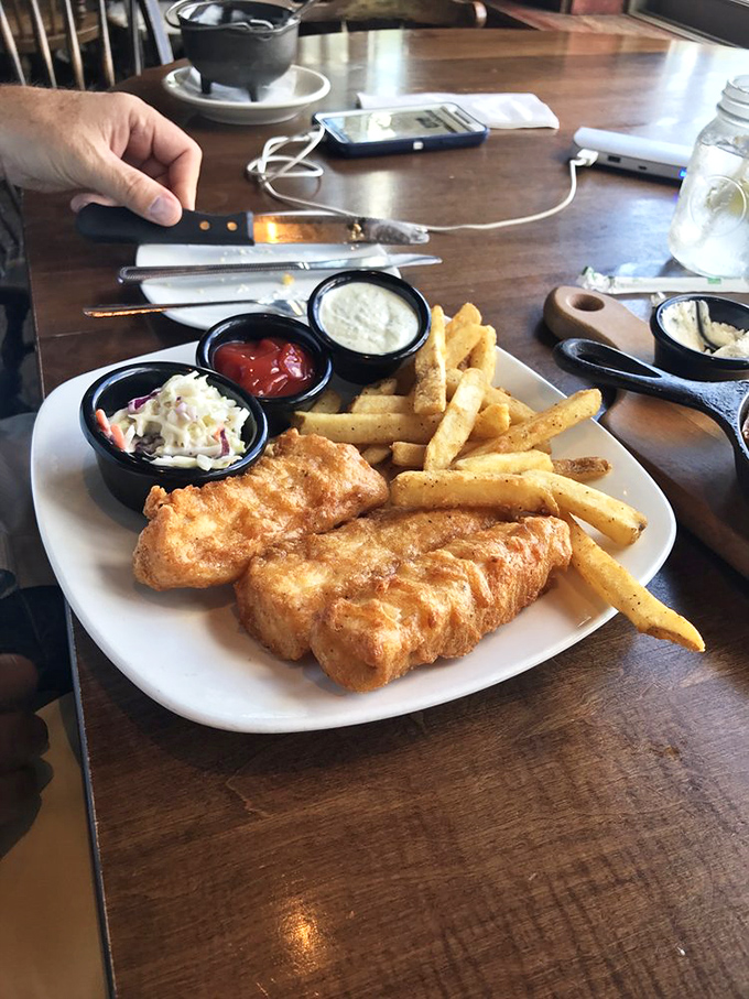 Golden-battered fish that shatters with each bite, paired with fries that somehow maintain their crispness from first to last. This is comfort perfected.