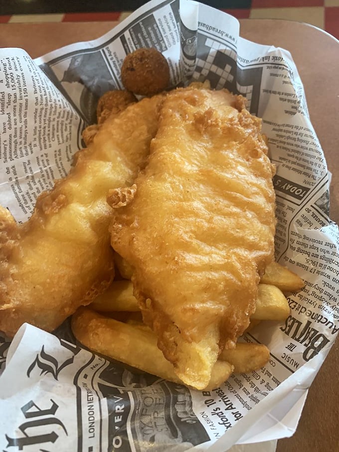 Golden-battered fish that shatters with each bite, nestled atop chips that would make any Brit nod in approval.