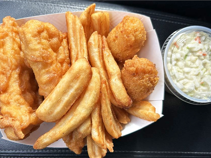 Golden-battered fish that shatters with each bite, alongside fries that could make a potato proud. The coleslaw provides the perfect cooling counterpoint.