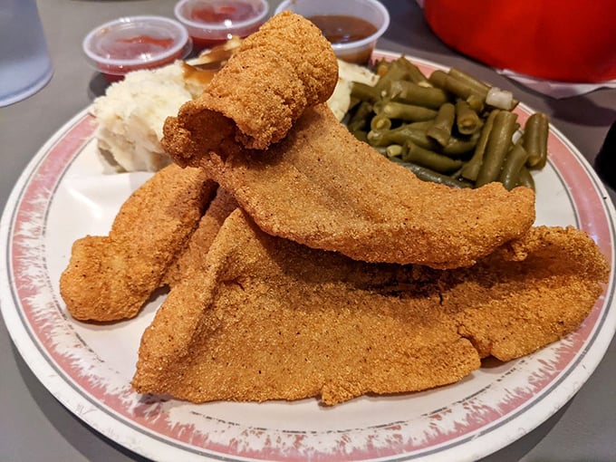 Golden-brown perfection on a plate. This catfish wears its cornmeal coating like a crispy badge of honor, ready for its tartar sauce sidekick.
