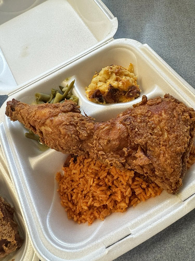 Golden-brown perfection meets red rice in a styrofoam container that might as well be labeled "happiness to go."