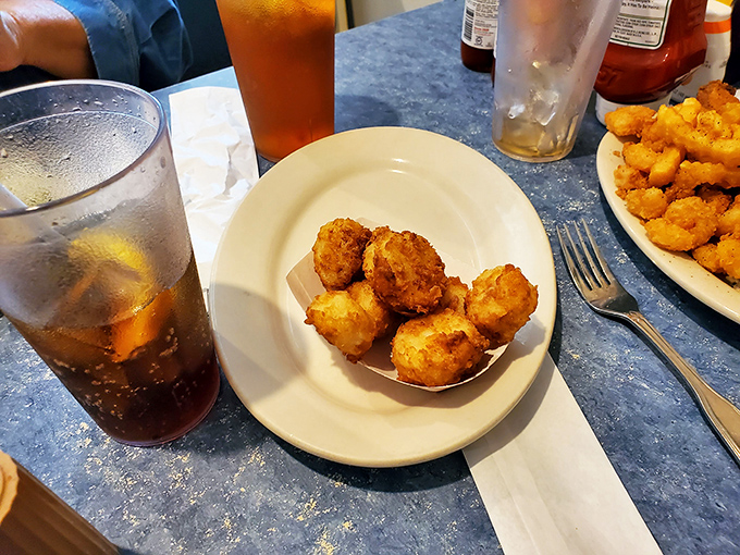 Golden-brown hushpuppies that could make a Southern grandmother weep with joy. These crispy orbs of cornmeal perfection are worth the trip alone.