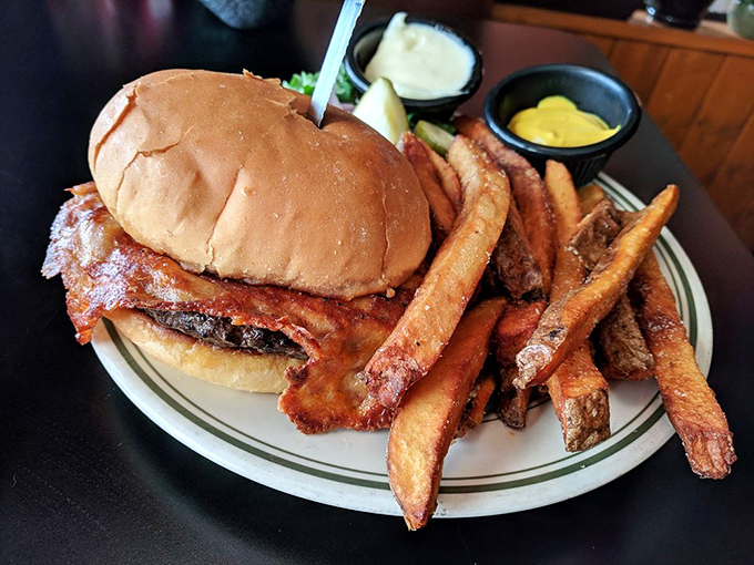 The burger arrives like a conquering hero, accompanied by golden fries standing at attention. This isn't just lunch&mdash;it's a declaration of deliciousness.