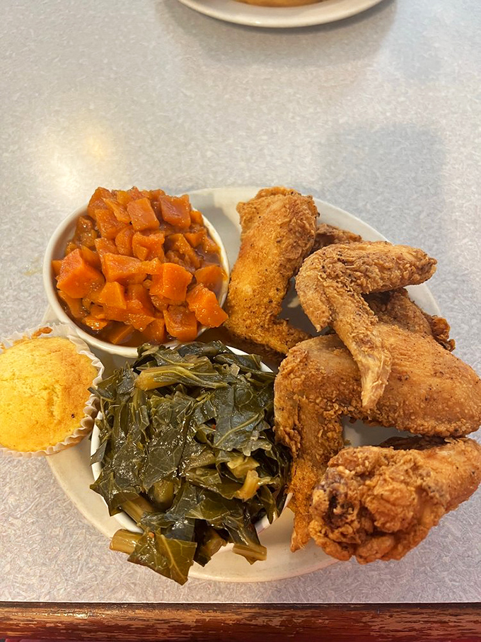 Soul food geometry at its finest: golden-crusted chicken, vibrant collards, and candied yams creating the perfect triangulation of Southern comfort.