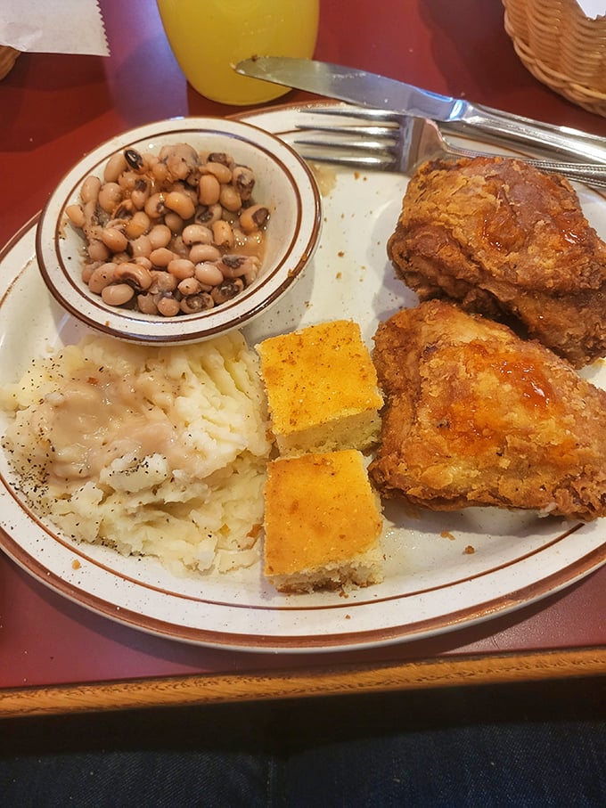 Southern perfection on a plate: crispy fried chicken, black-eyed peas, cornbread, and mashed potatoes that would make any grandma proud.