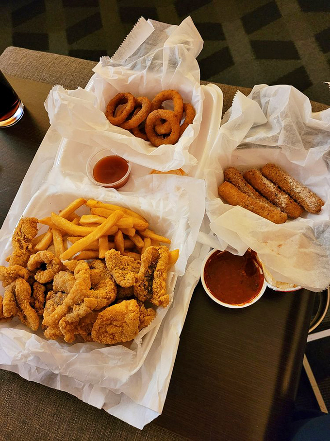 Seafood platter perfection: golden onion rings, crispy fish, and those french fries that somehow taste better when they're touching fried seafood.