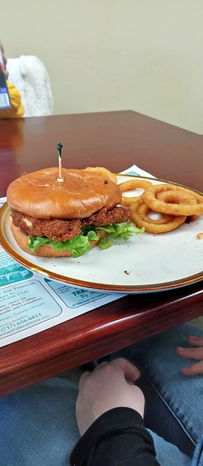 This isn't just a sandwich&mdash;it's an engineering marvel of crispy coating, juicy interior, and perfect bun-to-meat ratio. Those onion rings aren't playing a supporting role; they're co-stars.