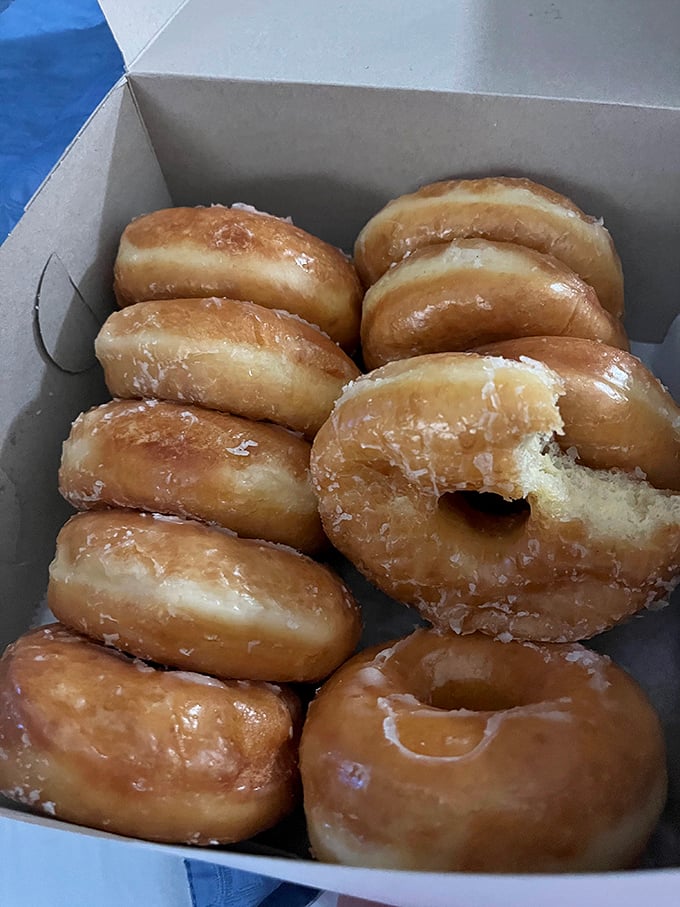 Glazed perfection in their natural habitat&mdash;the white box. That bite mark tells the story of someone who couldn't even wait to get home before surrendering to temptation.