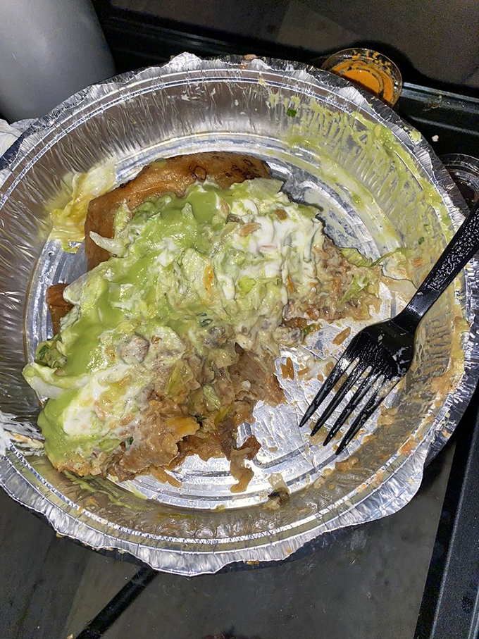 This half-eaten green chili burrito tells a story of passion interrupted only by the need to document the moment before devouring the rest.