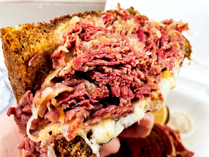 The holy trinity of deli perfection: House-cured corned beef, melted Swiss, and tangy sauerkraut stacked higher than Seattle's Space Needle.