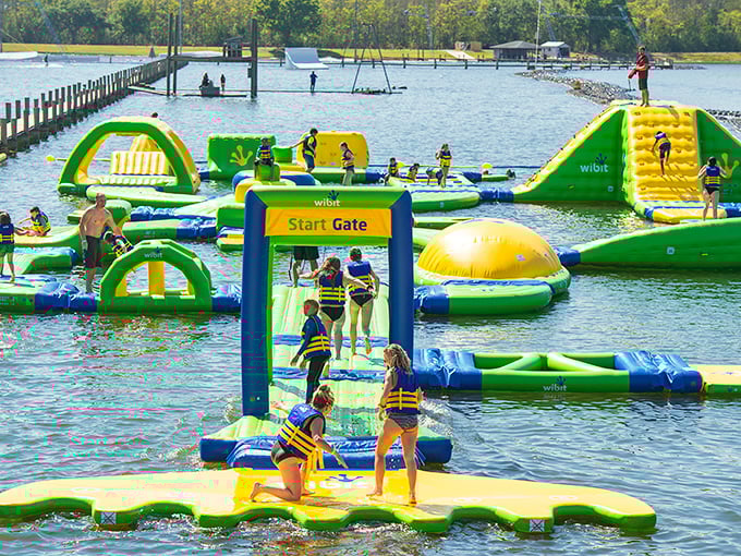 Families navigate the floating obstacle course, proving that "walking on water" is possible—just add inflatable platforms and a healthy dose of determination.