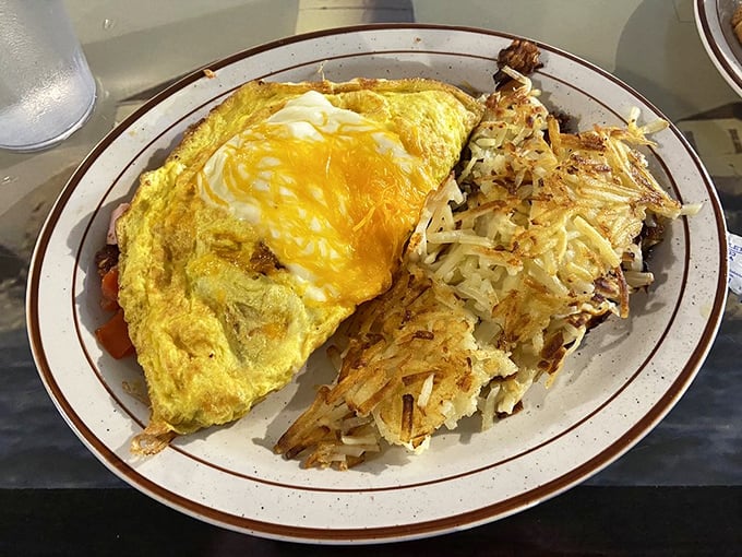 The Max Omelet arrives like a golden sunrise alongside hash browns with that perfect crisp-to-tender ratio that breakfast dreams are made of.