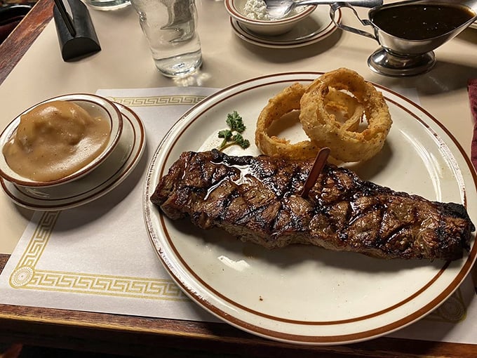 This isn't just dinner; it's a sacred ritual&mdash;perfectly seared New York Strip accompanied by golden onion rings and classic sides.