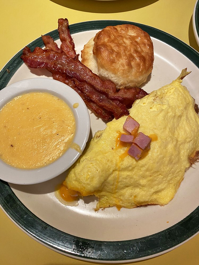 Breakfast nirvana achieved! A fluffy omelet, crispy bacon, cloud-like biscuit, and creamy grits create the quartet of morning perfection.