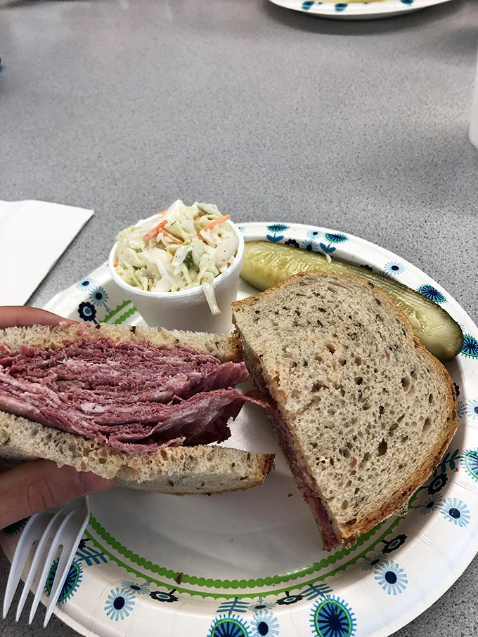 This isn't just a sandwich; it's architecture. Layers of pastrami creating a skyscraper of flavor, with coleslaw as the perfect structural support.