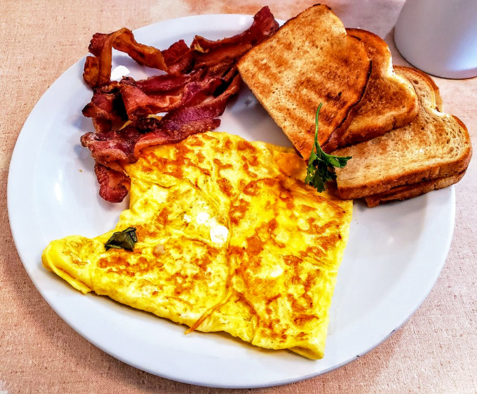 The classic breakfast trinity: a perfectly executed omelet, crispy bacon, and toast that's begging for a schmear of butter. Simple food done right never goes out of style.