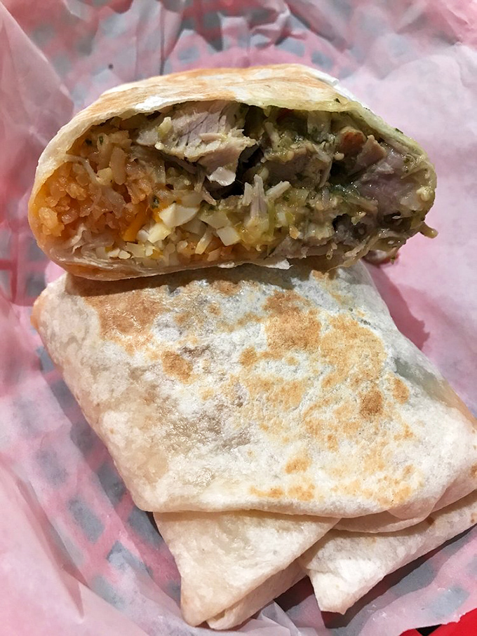 Behold the star of our show! The pork chile verde burrito reveals its treasure trove of tender meat, rice, and that legendary green sauce that haunts dreams.