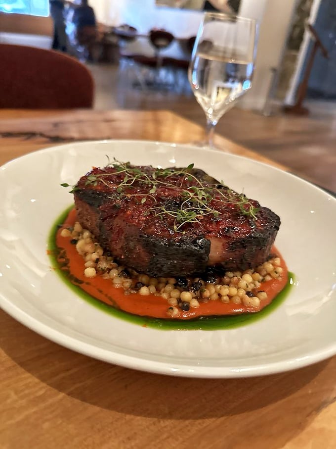 The star of the show in all its glory: a perfectly seared pork ribeye resting on pearls of farro, surrounded by a sauce that should be bottled and sold.