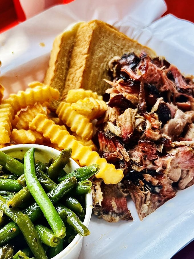 Tender pulled pork with that signature smoke ring, partnered with green beans and crinkle-cut fries &ndash; the holy trinity of Southern comfort.