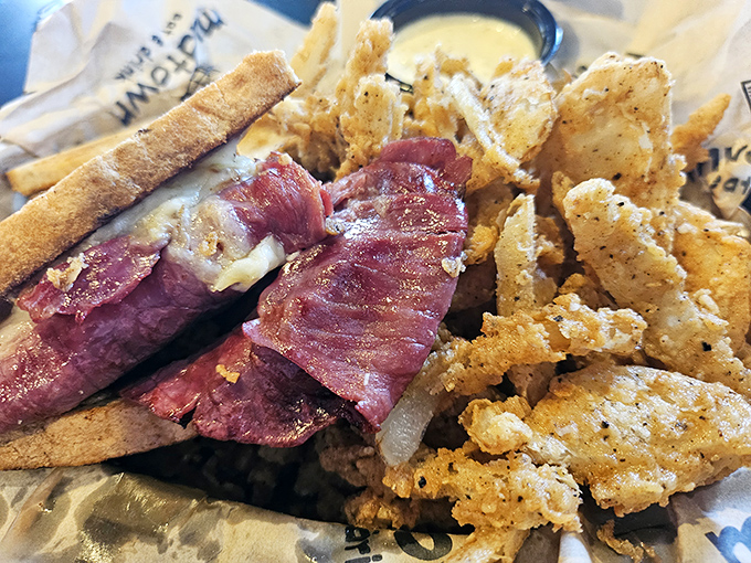 The infamous Reuben in all its glory &ndash; meat stacked higher than my college textbooks, with melty cheese cascading down the sides like delicious lava.