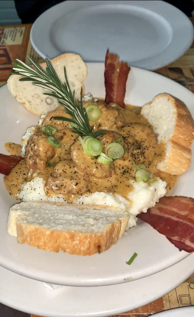 This isn't just shrimp and grits; it's a love letter to New Orleans cuisine with plump Gulf shrimp, creamy grits, and that rosemary sprig saying "Oh, hello there."