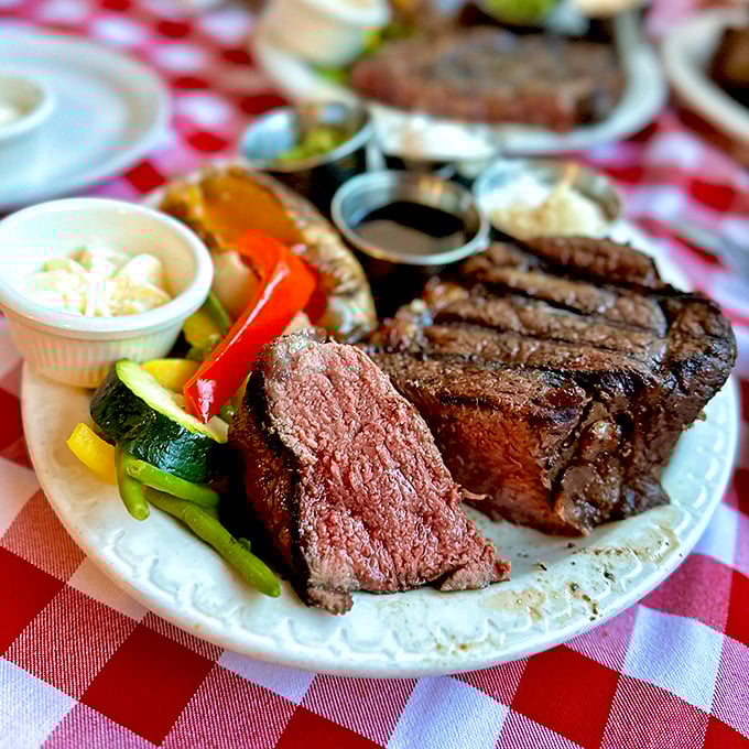 A perfectly seared steak reveals its blushing interior &ndash; the kind of meat that makes vegetarians question their life choices, if only momentarily.