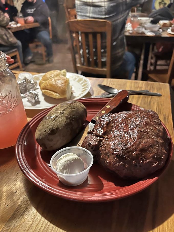 The main event arrives: a steak that would make Fred Flintstone jealous, accompanied by a foil-wrapped potato that could feed a small family.