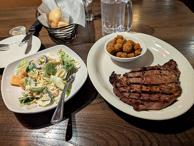 A steak with perfect grill marks flanked by a salad and fried okra&mdash;the holy trinity of Southern steakhouse dining.