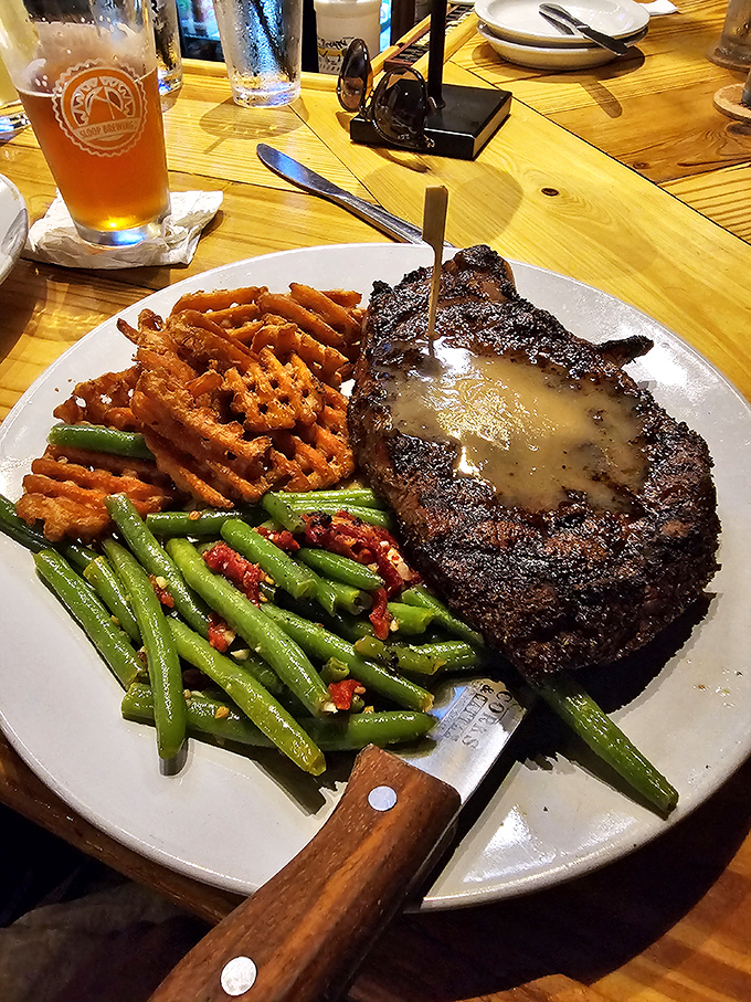 The steak doesn't just sit on the plate&mdash;it commands attention like Pavarotti on stage, with sweet potato waffle fries playing backup.