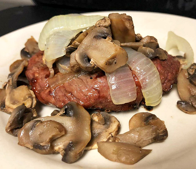 This steak, adorned with saut&eacute;ed mushrooms and onions, isn't just dinner&mdash;it's edible poetry that speaks the universal language of "mmmmm."