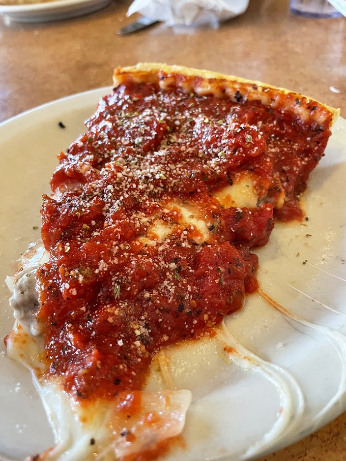Architecture of deliciousness! That cross-section reveals the magnificent layers of sauce, cheese, and crust that define Zachary's stuffed pizza experience.