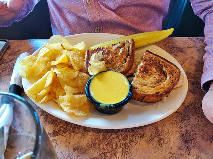 This isn't just lunch—it's a monument to simplicity done right. Golden-crisp bread, perfectly melted cheese, and a pickle spear standing guard like a delicious sentinel.