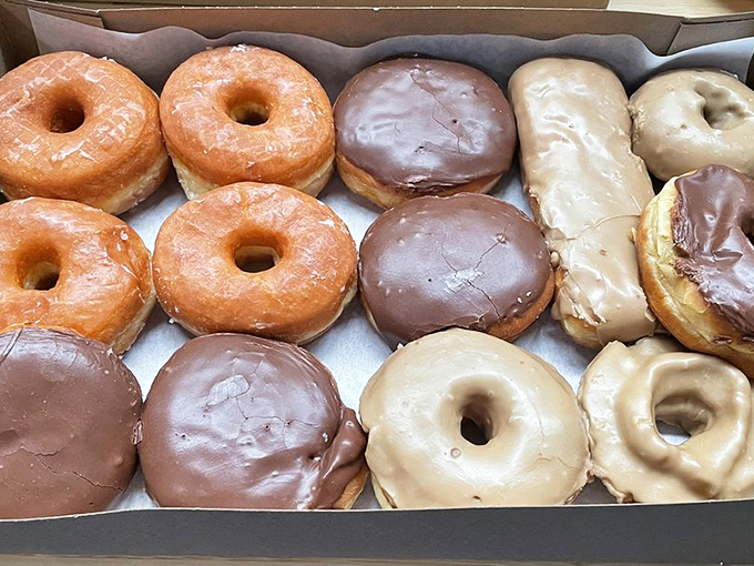 Behold the holy grail of breakfast: perfectly glazed donuts lined up like soldiers ready for duty. Your diet plan's worst nightmare, your taste buds' dream come true. 