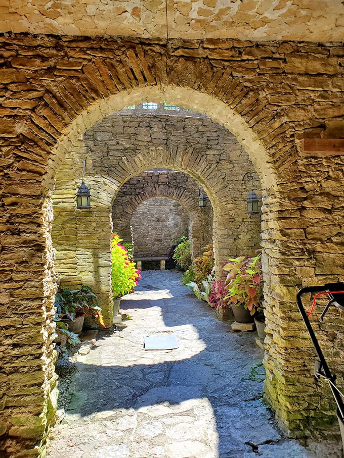 Stone archways frame a sunlit path through the castle grounds. Walking through feels like stepping into a portal where Ohio dissolves and medieval Europe materializes.